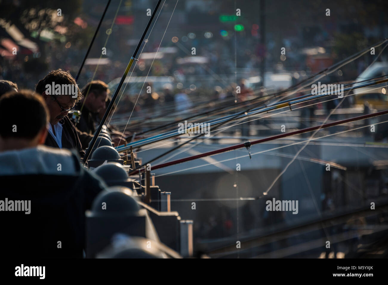 Galata Bridge lined with fishermen and fish restaurants Stock Photo - Alamy