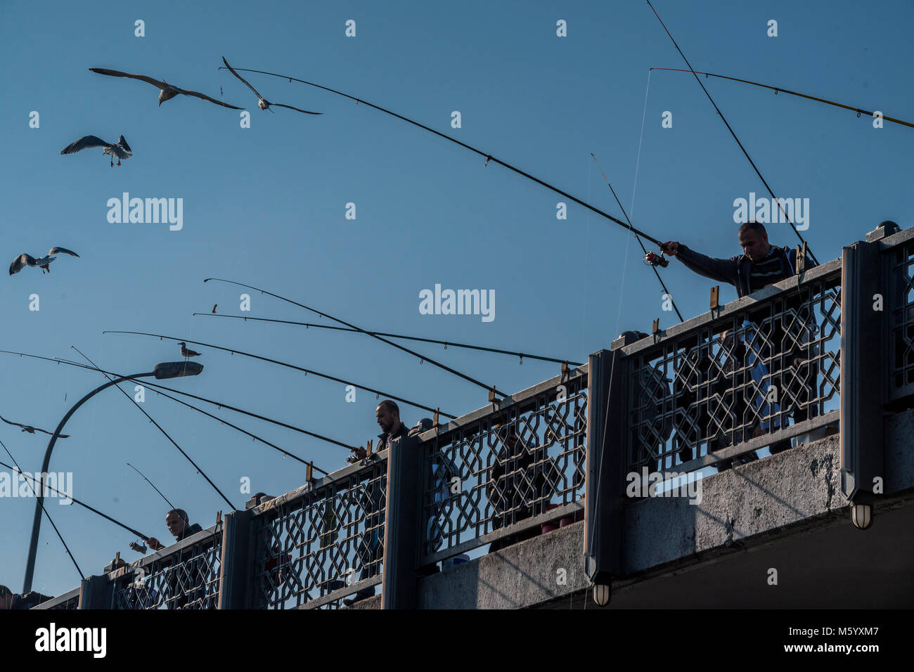 Galata Bridge lined with fishermen and fish restaurants Stock Photo - Alamy