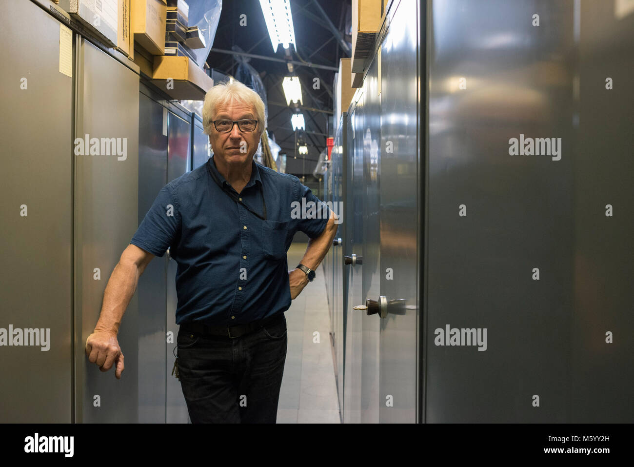 a museum worker poses amongst the collection and archive of the booth ...