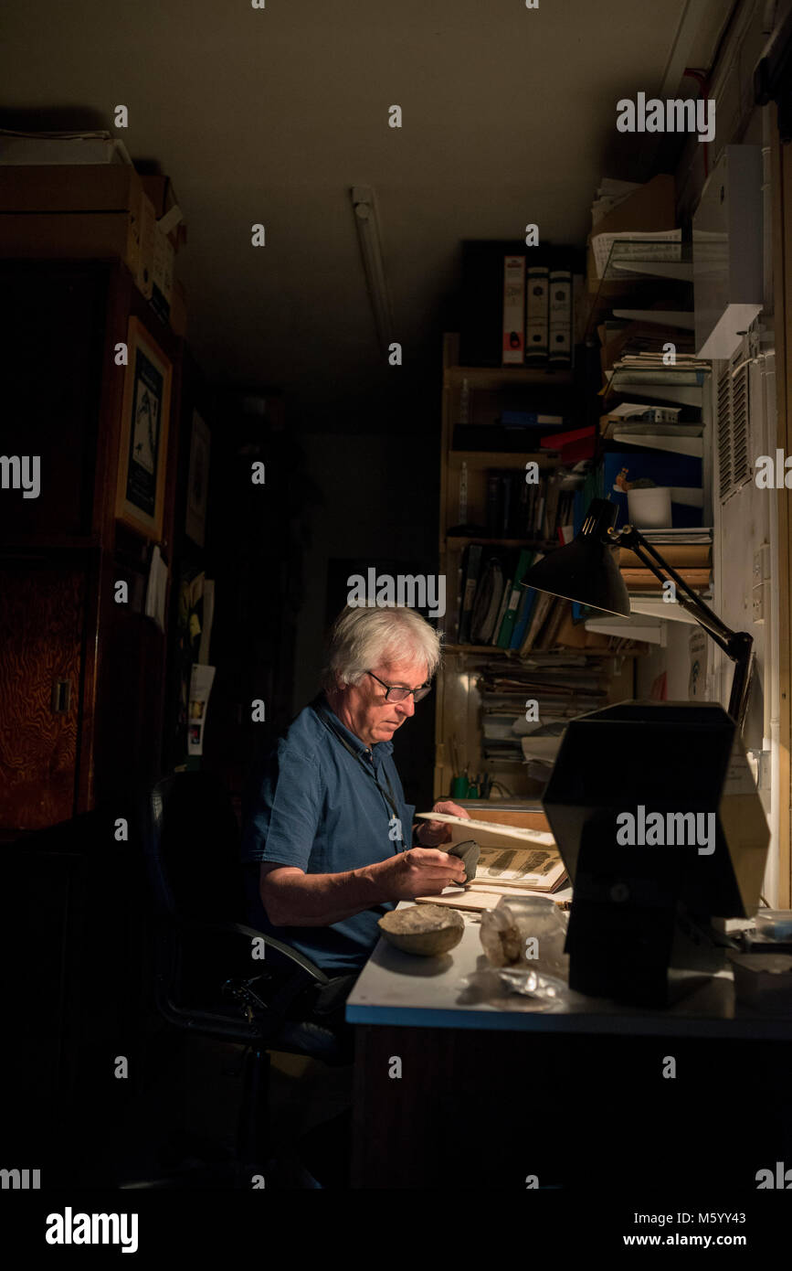 a museum worker poses amongst the collection and archive of the booth ...