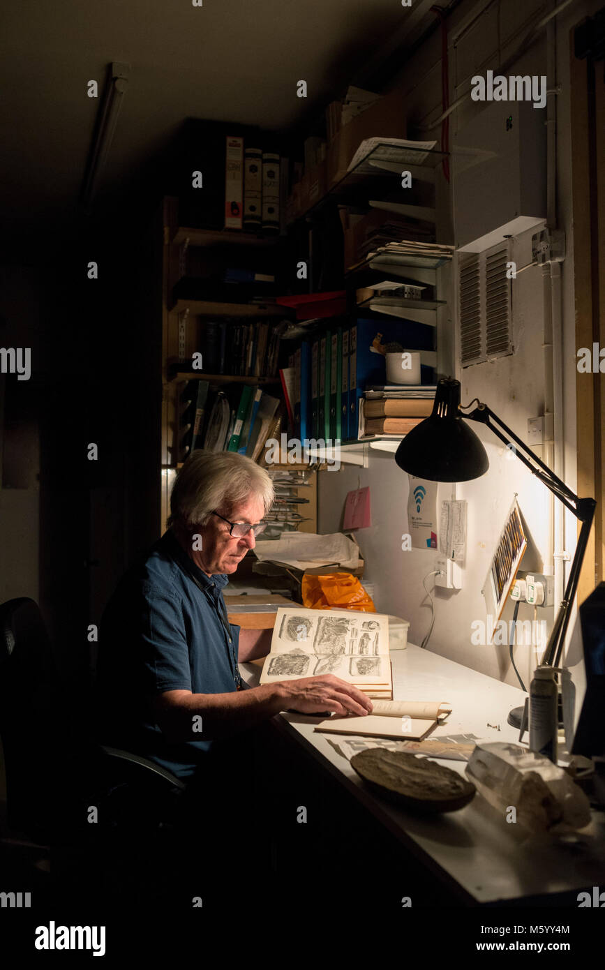 a museum worker poses amongst the collection and archive of the booth ...
