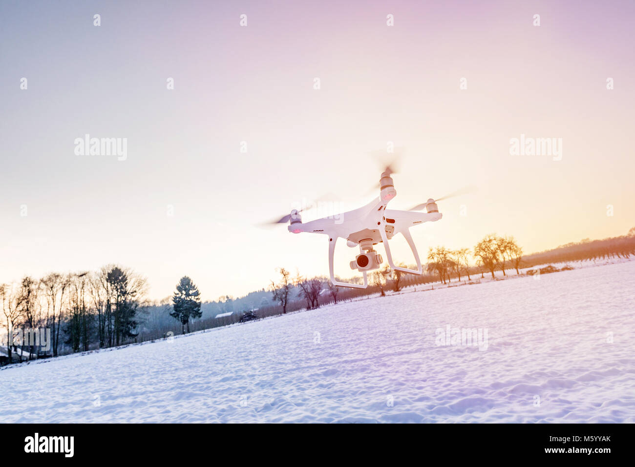 Photo of a flying white professional quadcopter drone camera in the air ...