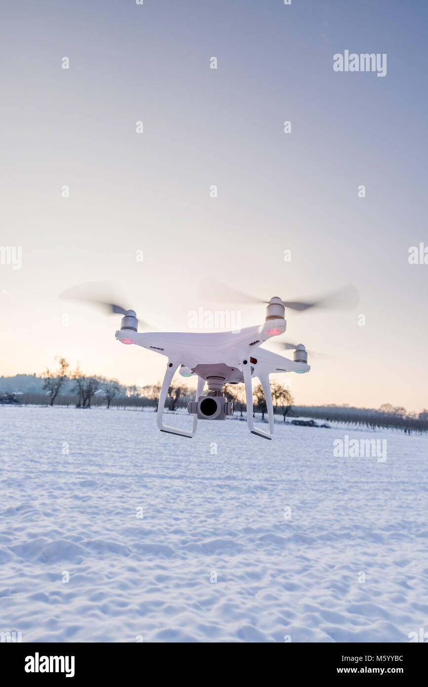 Photo of a flying white professional quadcopter drone camera in the air ...