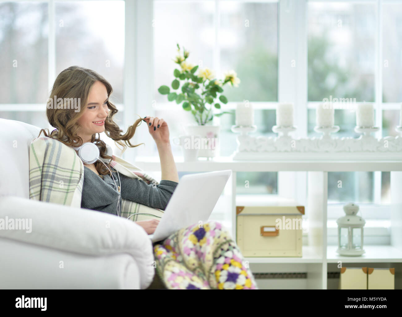 woman sitting in armchair using laptop Stock Photo - Alamy