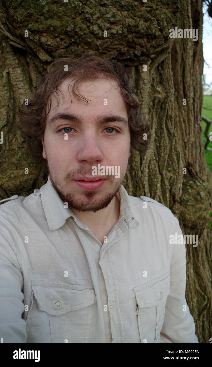 Ruggedly Handsome Young Man in a Safari Shirt Leaning against an Old ...