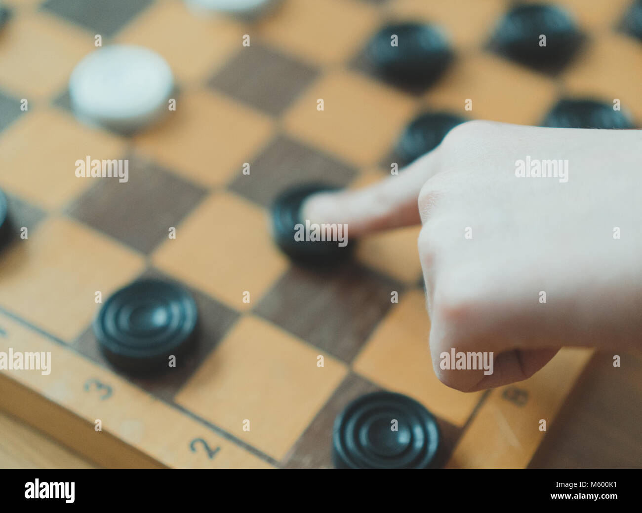 Child playing checkers board game. Close-up view Stock Photo - Alamy