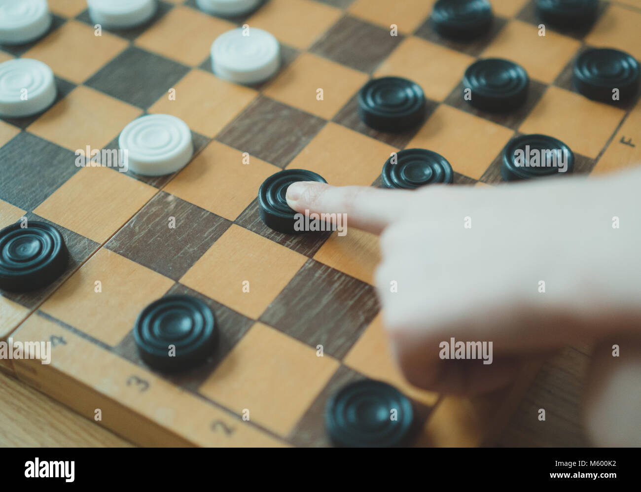 Child playing checkers board game. Close-up view Stock Photo - Alamy