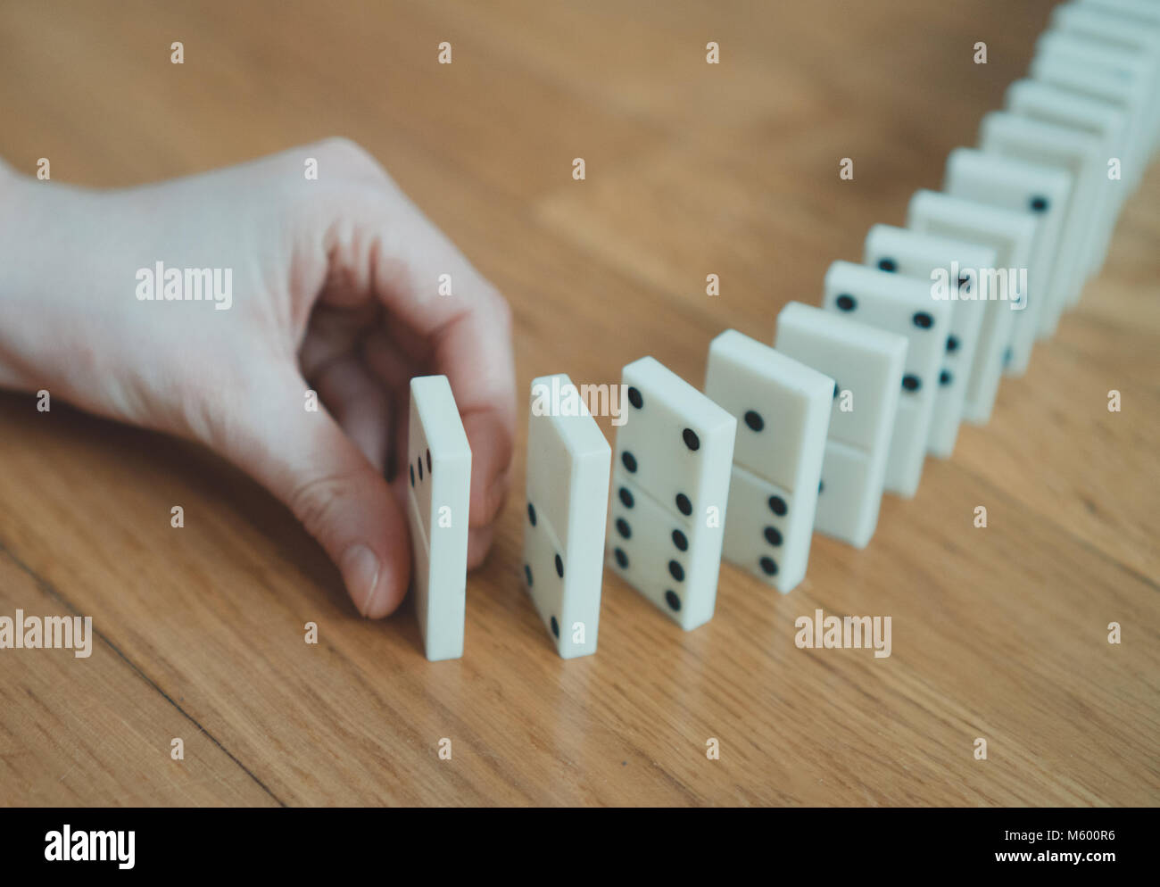 Child playing placing dominoes on the floor Stock Photo - Alamy