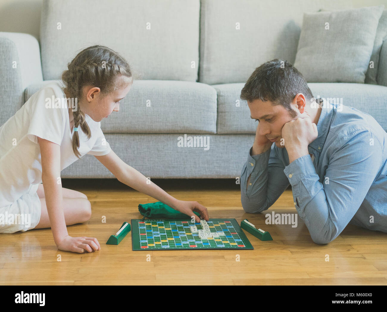 Little girl and her father playing scrabble board game Stock Photo - Alamy