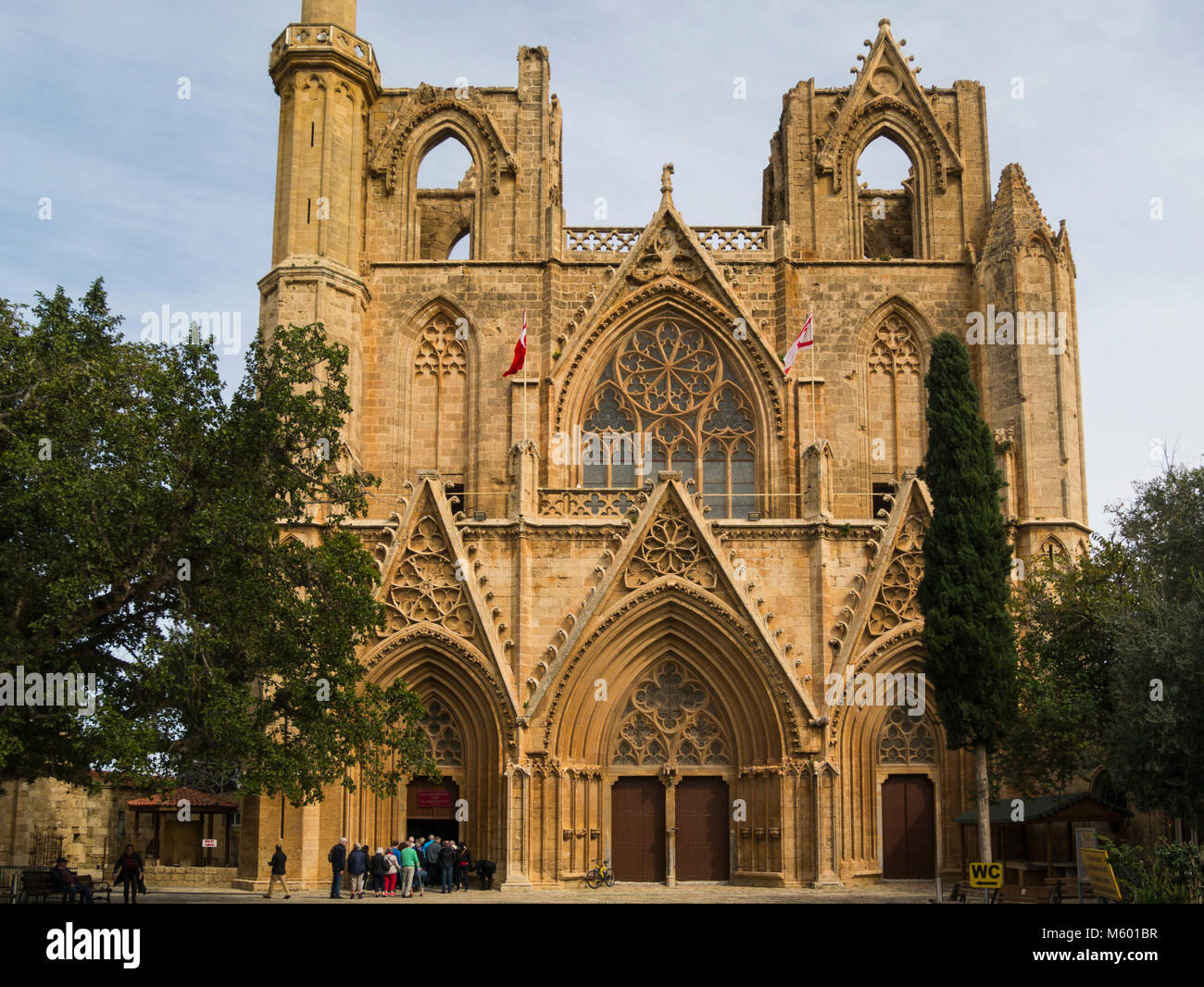 Group of tourists entering huge honey-colored Lala Mustafa Pasha Mosque ...