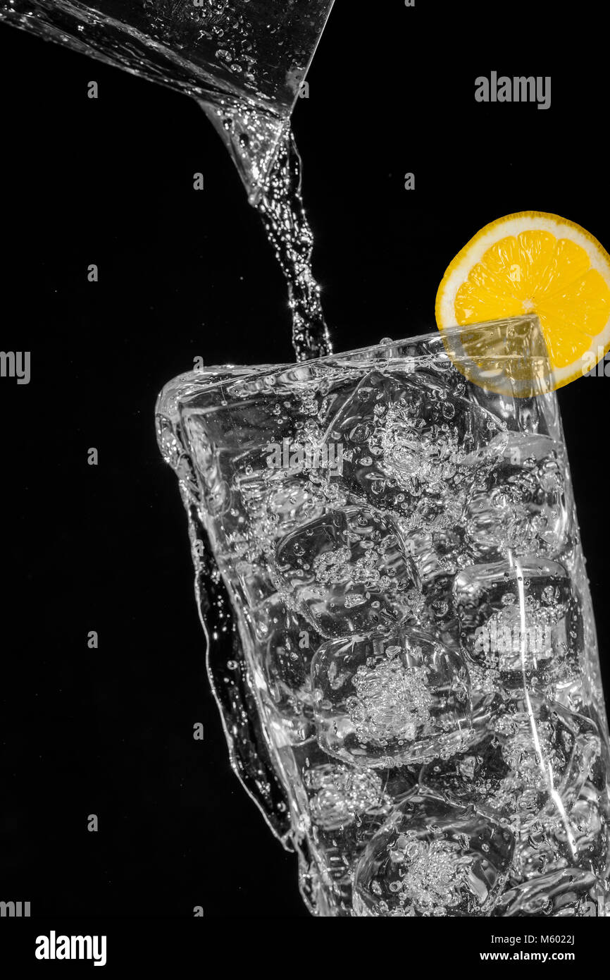 sparkling water overflow over ice cubes Stock Photo - Alamy