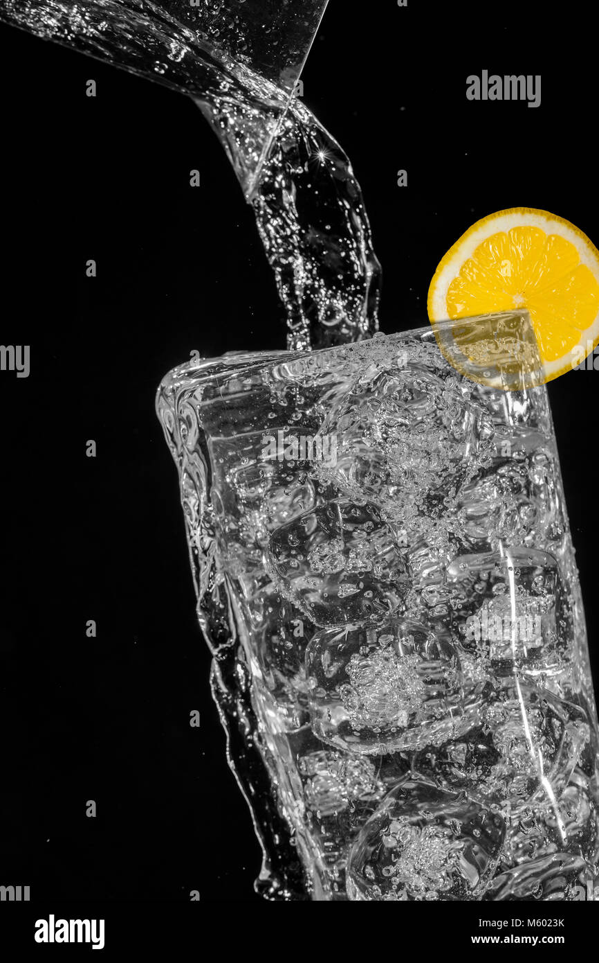 sparkling water overflow over ice cubes Stock Photo - Alamy