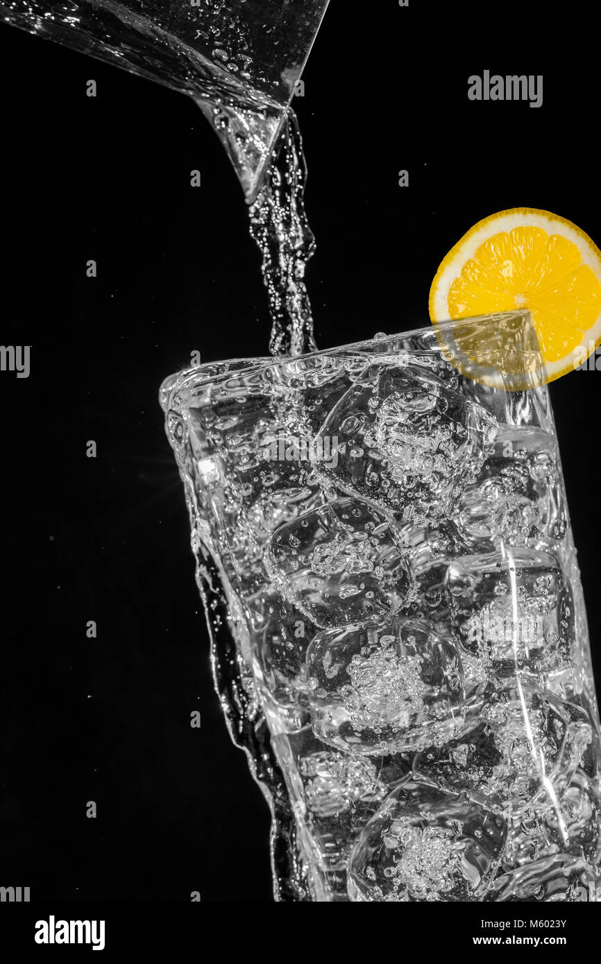 sparkling water overflow over ice cubes Stock Photo - Alamy