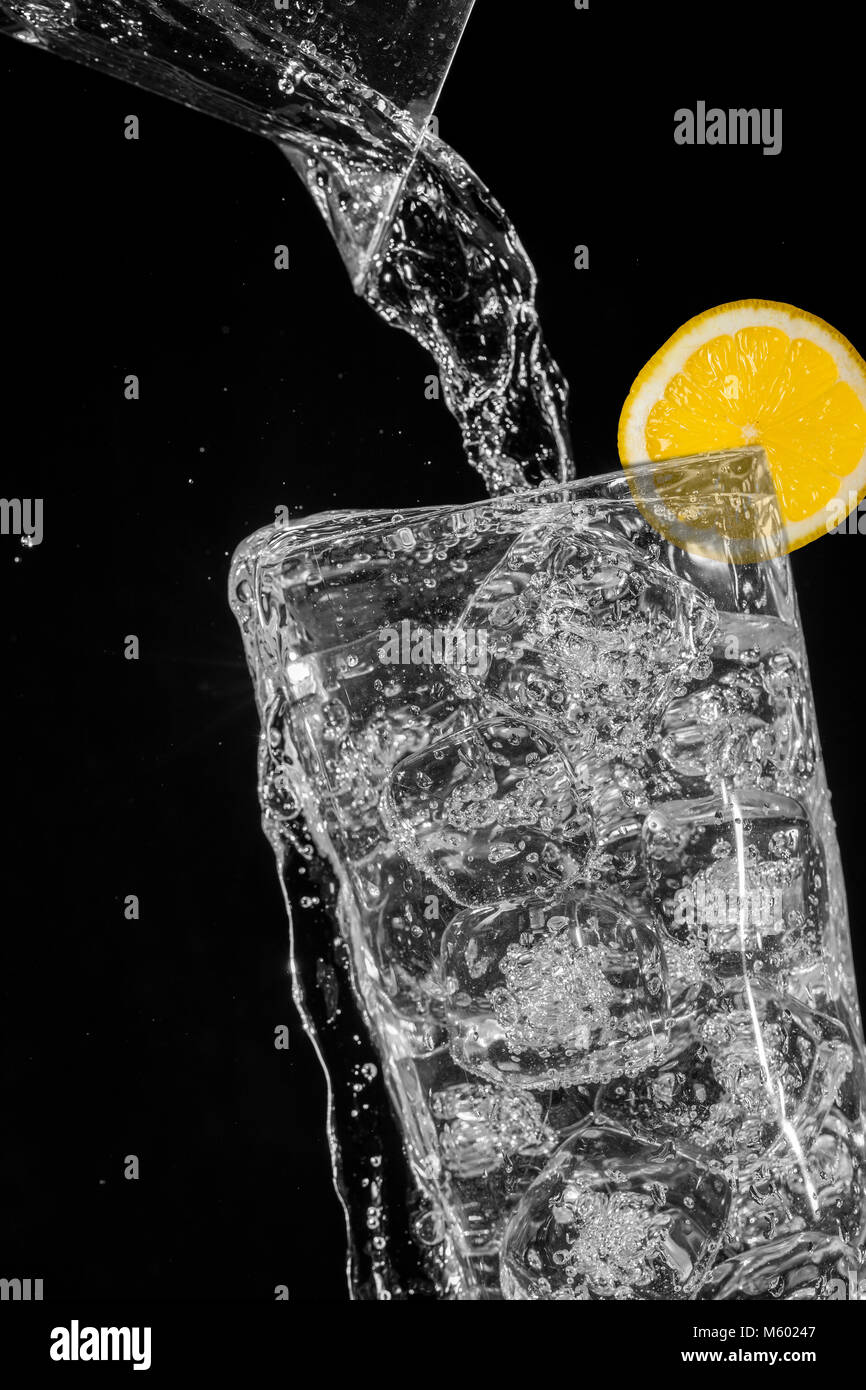 sparkling water overflow over ice cubes Stock Photo - Alamy