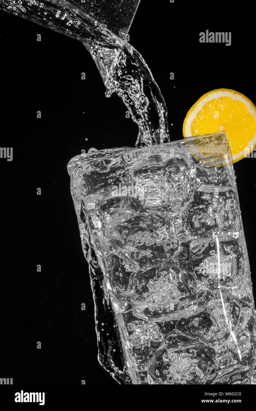 sparkling water overflow over ice cubes Stock Photo - Alamy