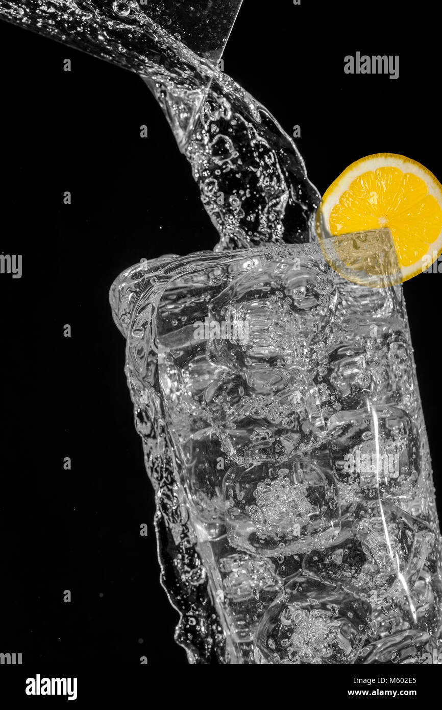 sparkling water overflow over ice cubes Stock Photo - Alamy