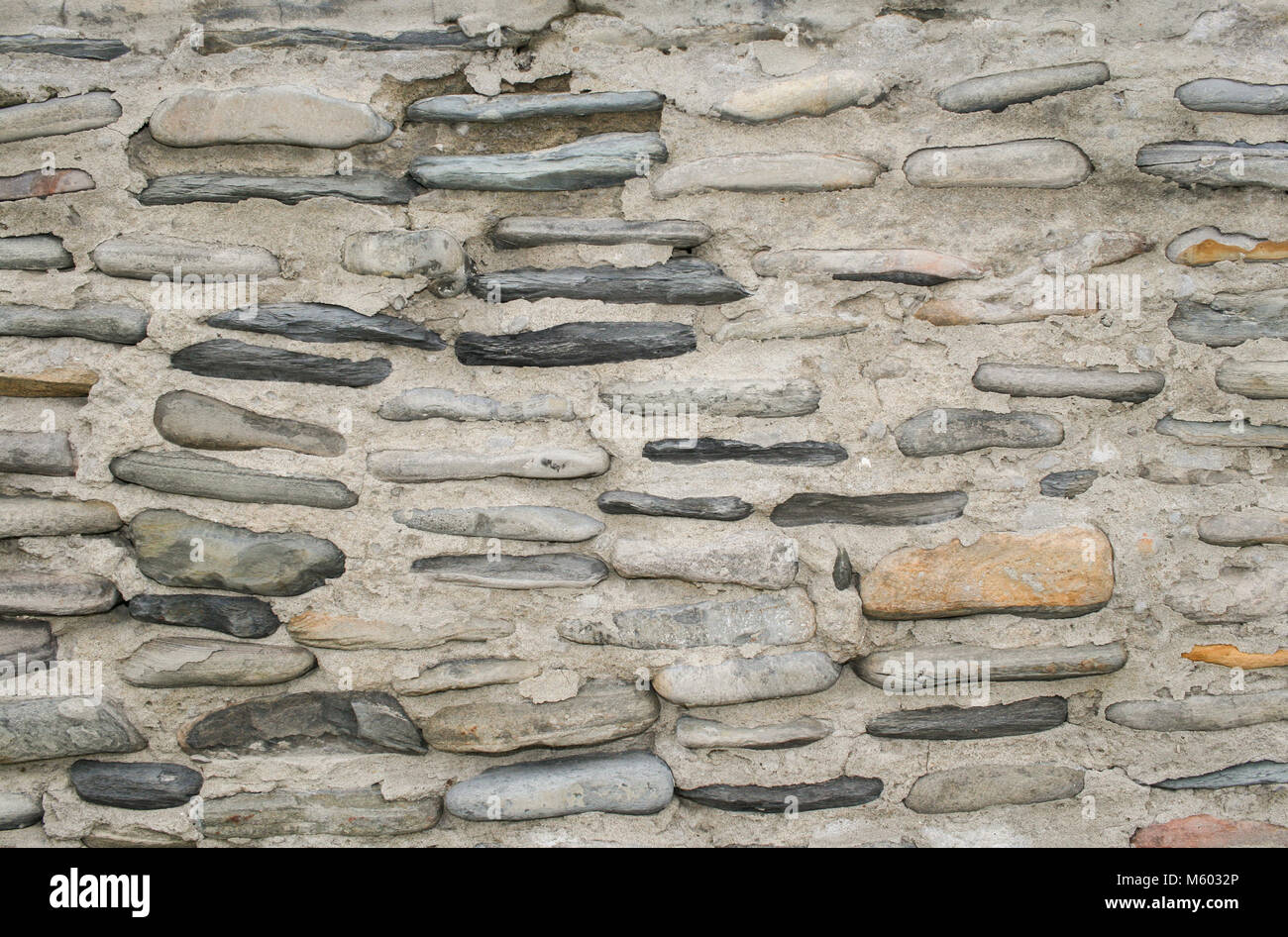 Close-up a concrete wall with the smooth sea boulders in it Stock Photo ...