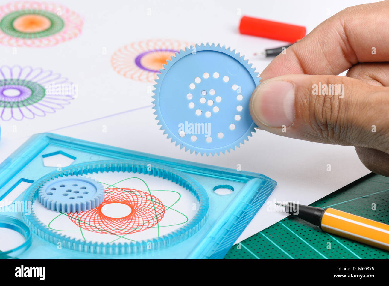 Drawing the spirograph pattern with spirograph kit Stock Photo - Alamy