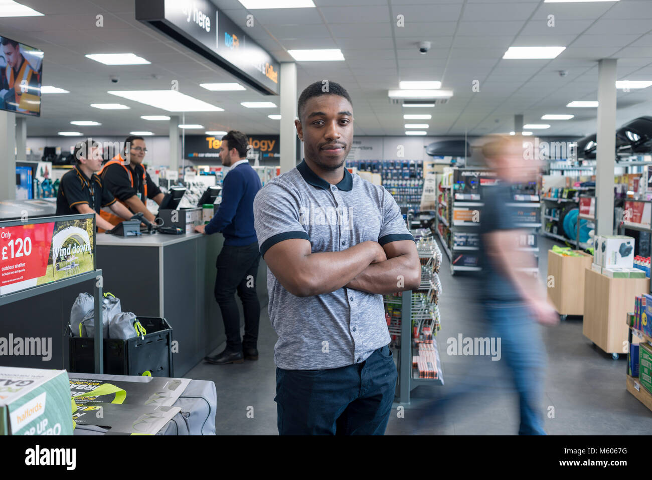 a real person / customer stands in a halfords autocentre with the sales ...
