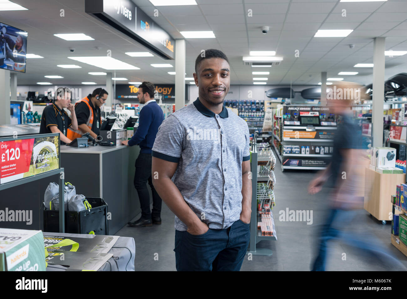 a real person / customer stands in a halfords autocentre with the sales ...