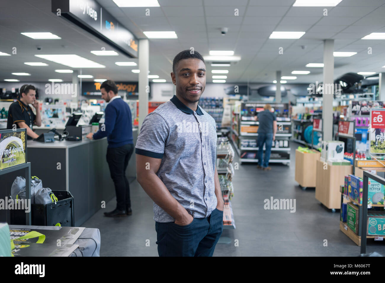 a real person / customer stands in a halfords autocentre with the sales ...