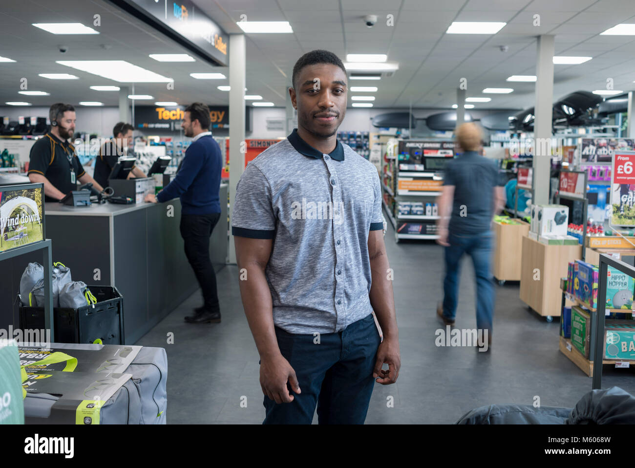 a real person / customer stands in a halfords autocentre with the sales ...