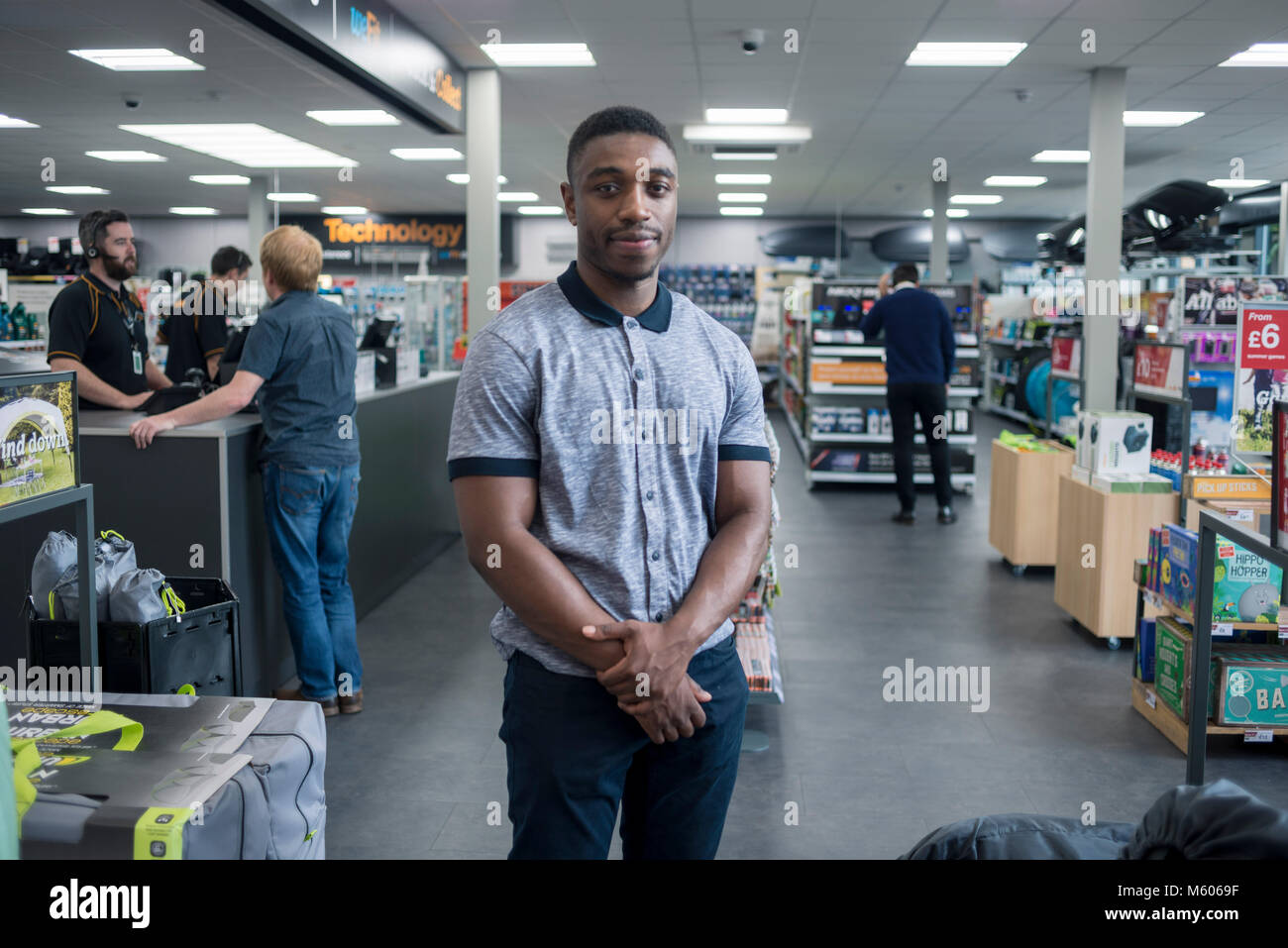 a real person / customer stands in a halfords autocentre with the sales ...