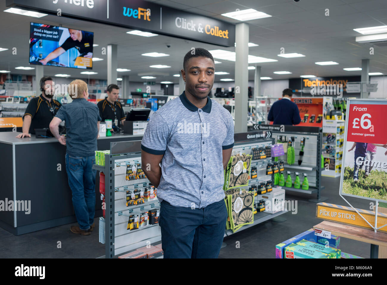 a real person / customer stands in a halfords autocentre with the sales ...