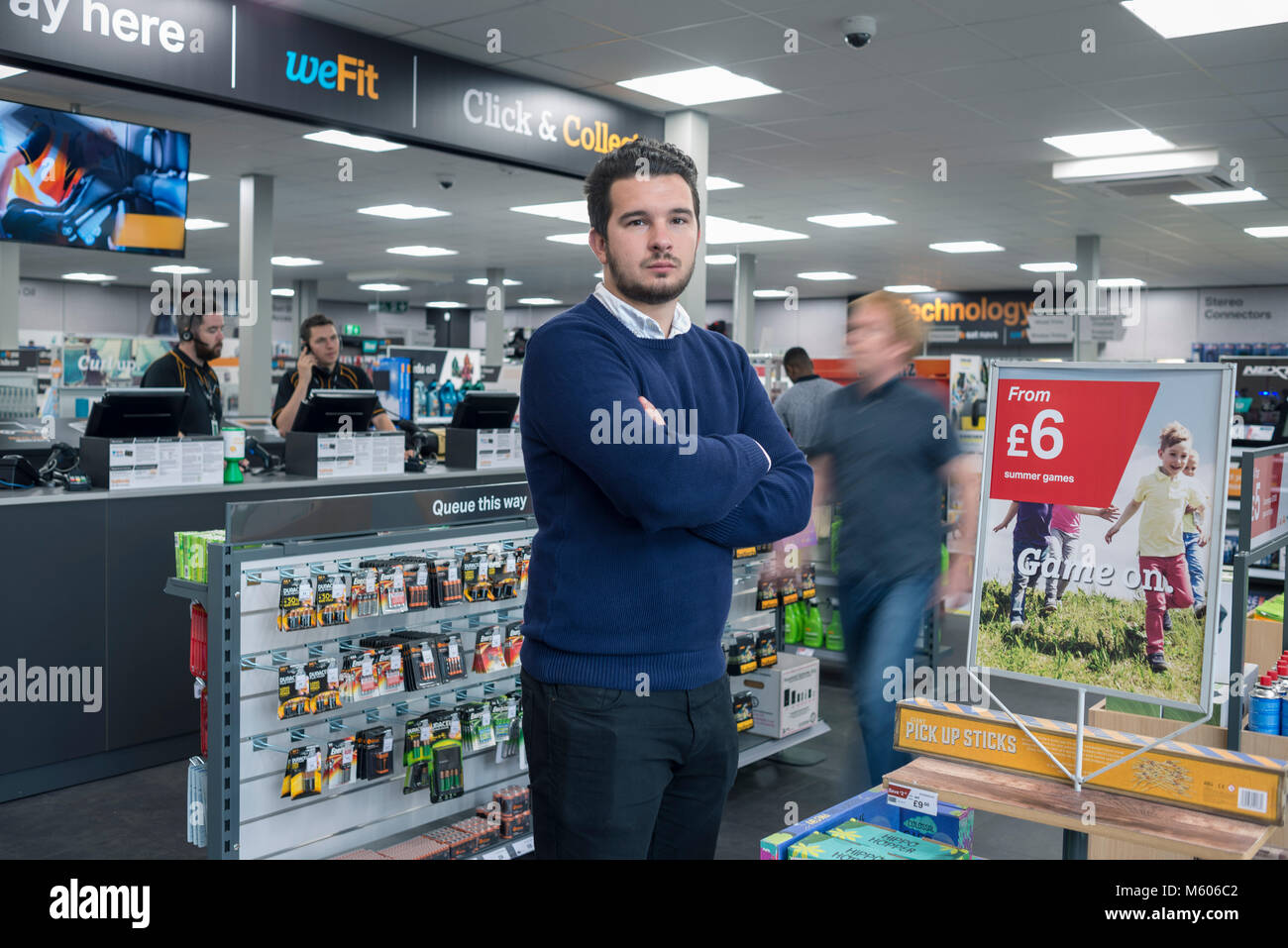 a real person / customer stands in a halfords autocentre with the sales ...
