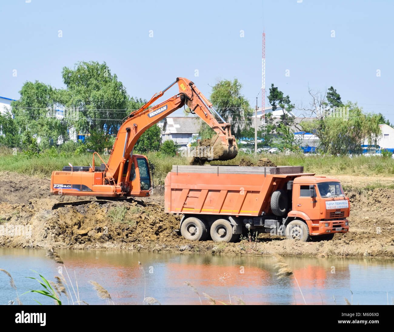 The excavator pours clay into the truck body. Quarry with clay Stock ...