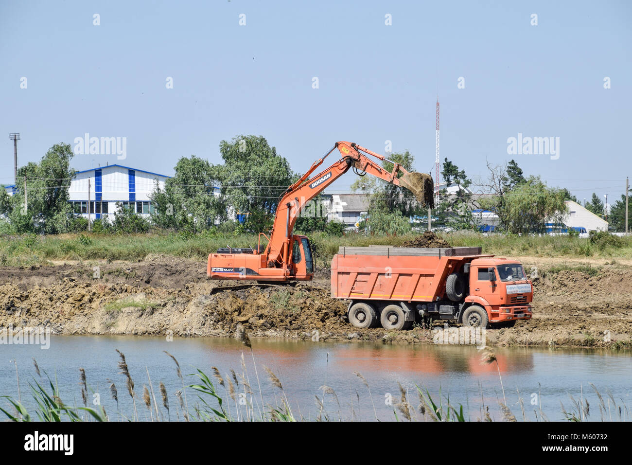 The excavator pours clay into the truck body. Quarry with clay Stock ...
