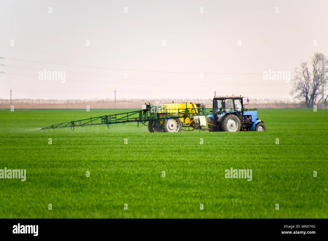 Tractor making fertilizer by spray Stock Photo - Alamy