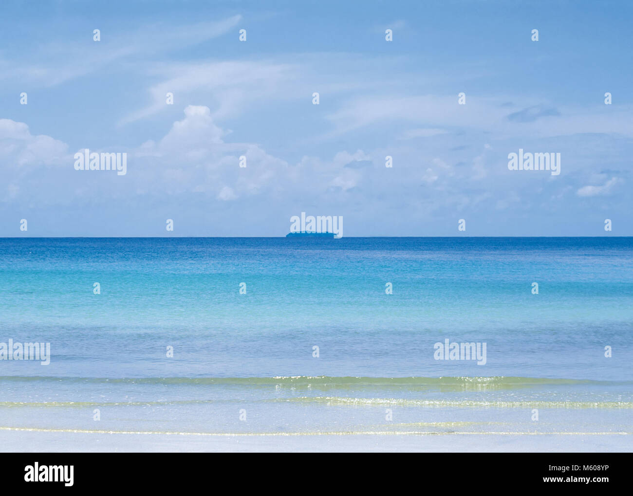 Pristine quite tropical sea with distant island on horizon and small ...