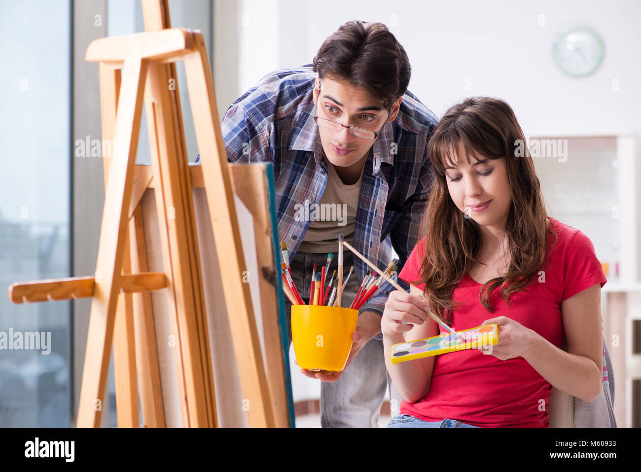 Artist coaching student in painting class in studio Stock Photo - Alamy