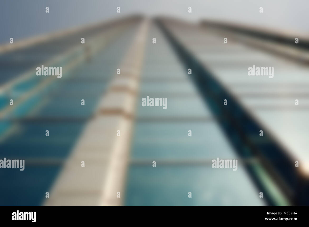 Blurred image of modern skyscraper against a blue sky Stock Photo - Alamy