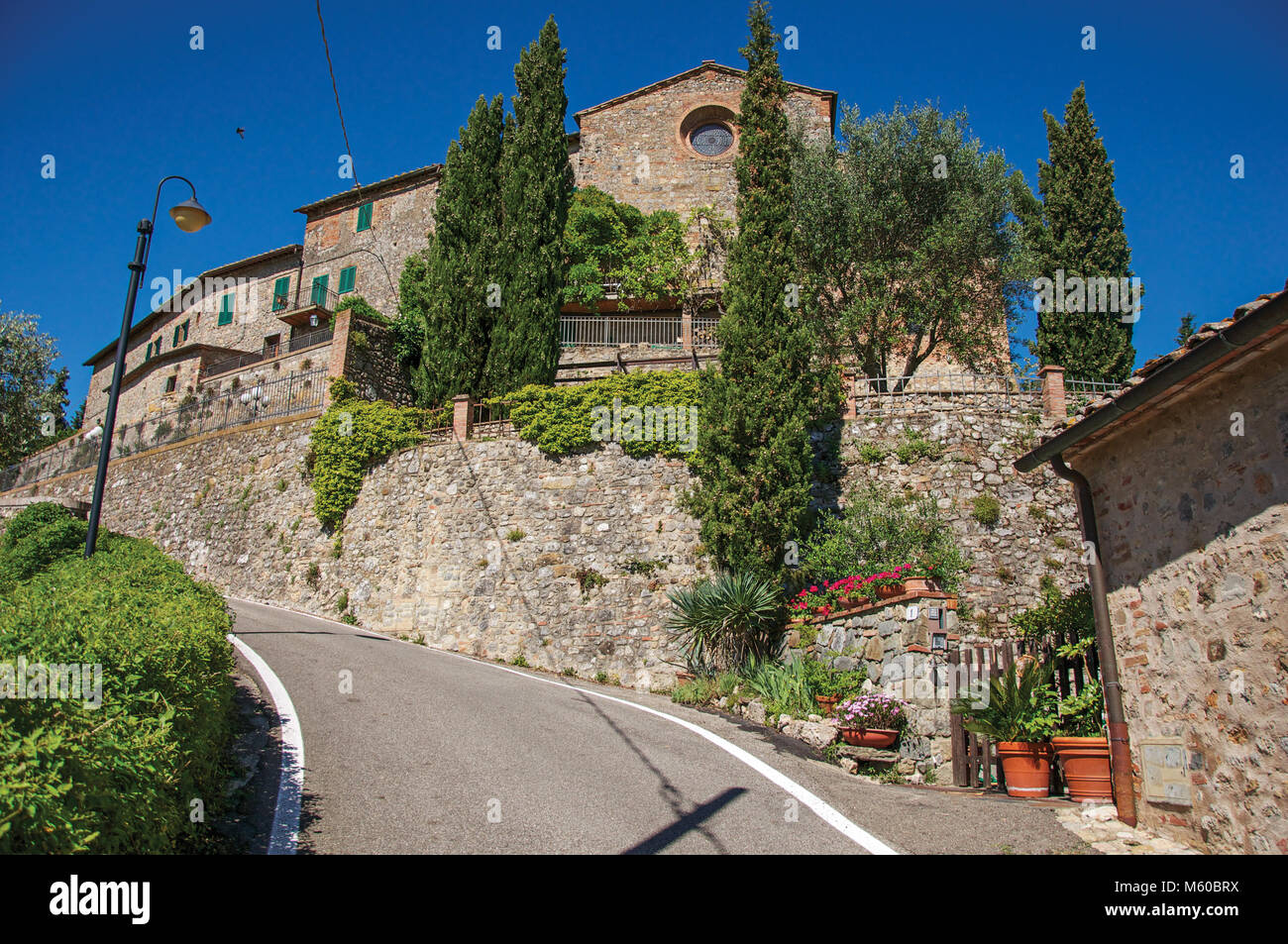 Tuscany, Italy. View of wall, old houses and church near road in the ...