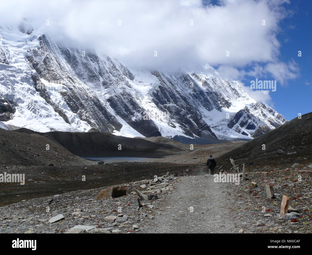 Beautiful mountain path under snow capped Himalaya to the Tilicho lake ...