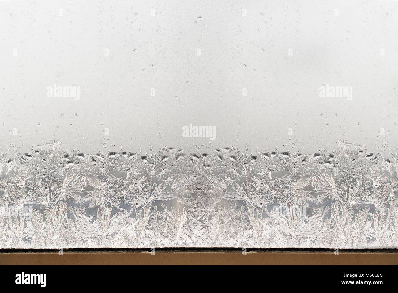 Frost patterns at window glass. Closeup Stock Photo - Alamy