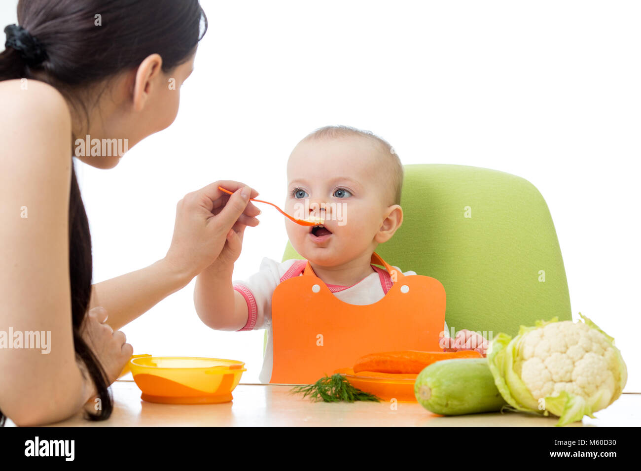 Pretty baby eating with spoon Stock Photo - Alamy