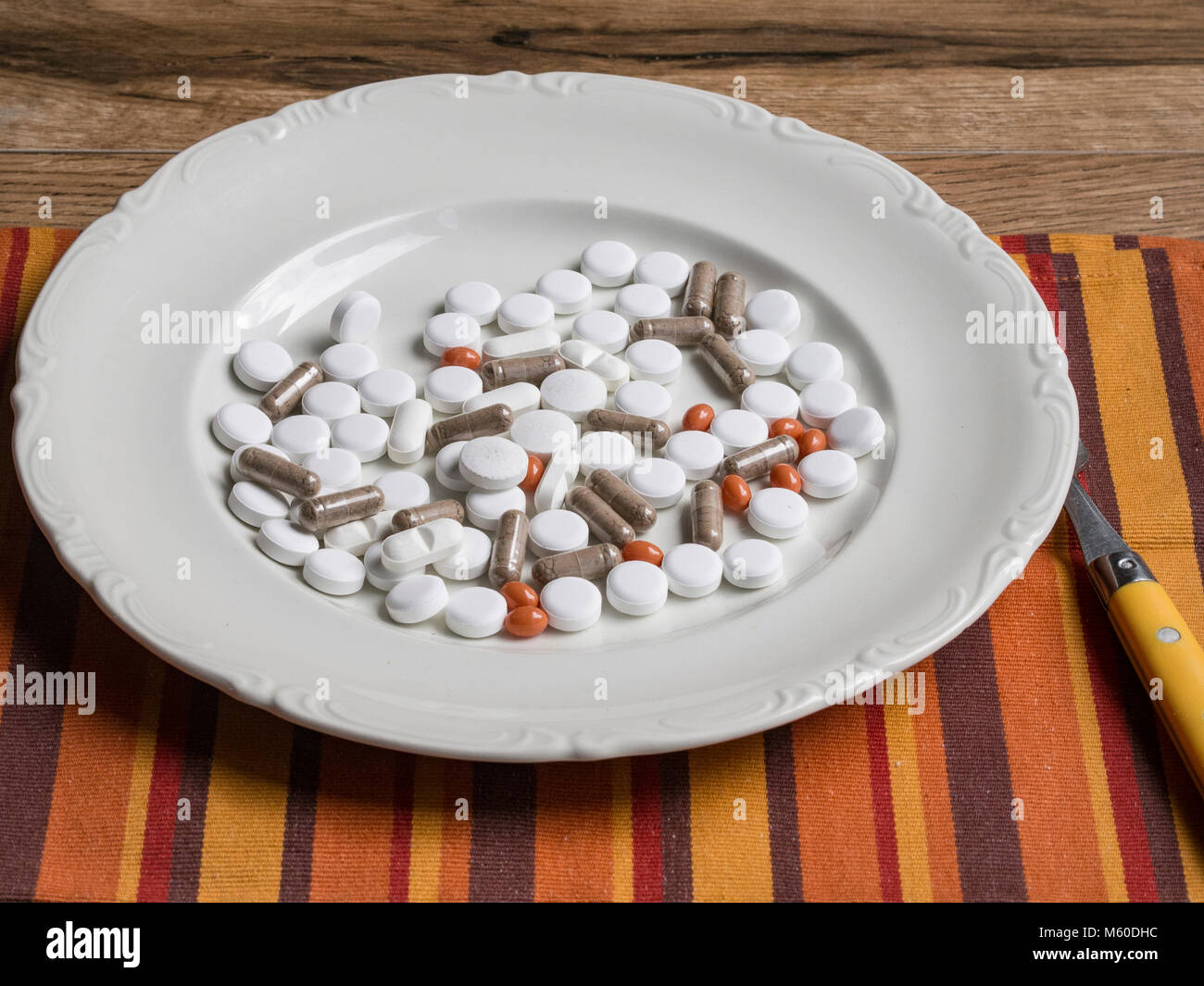 Group of pills in a plate on the table Stock Photo - Alamy