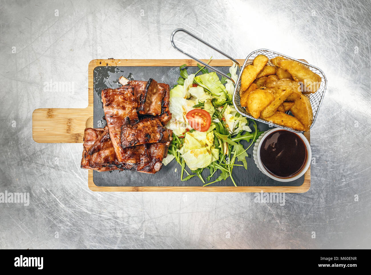 Roasted meat with potato wedges and fresh rocket salad Stock Photo - Alamy