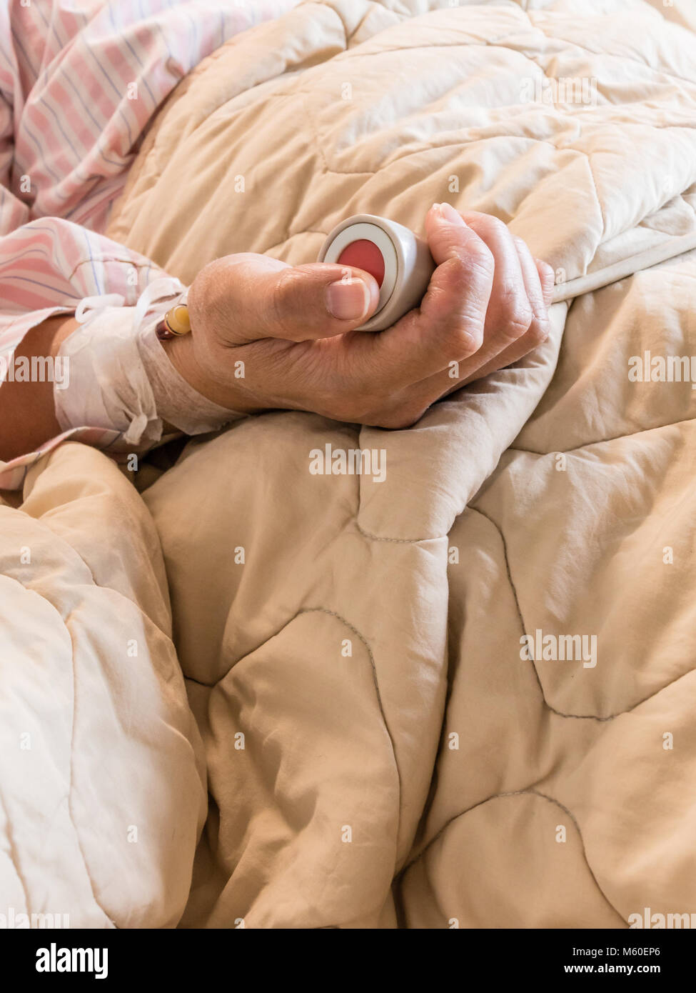 Woman pushing emergency button in hospital bed, health care concept ...
