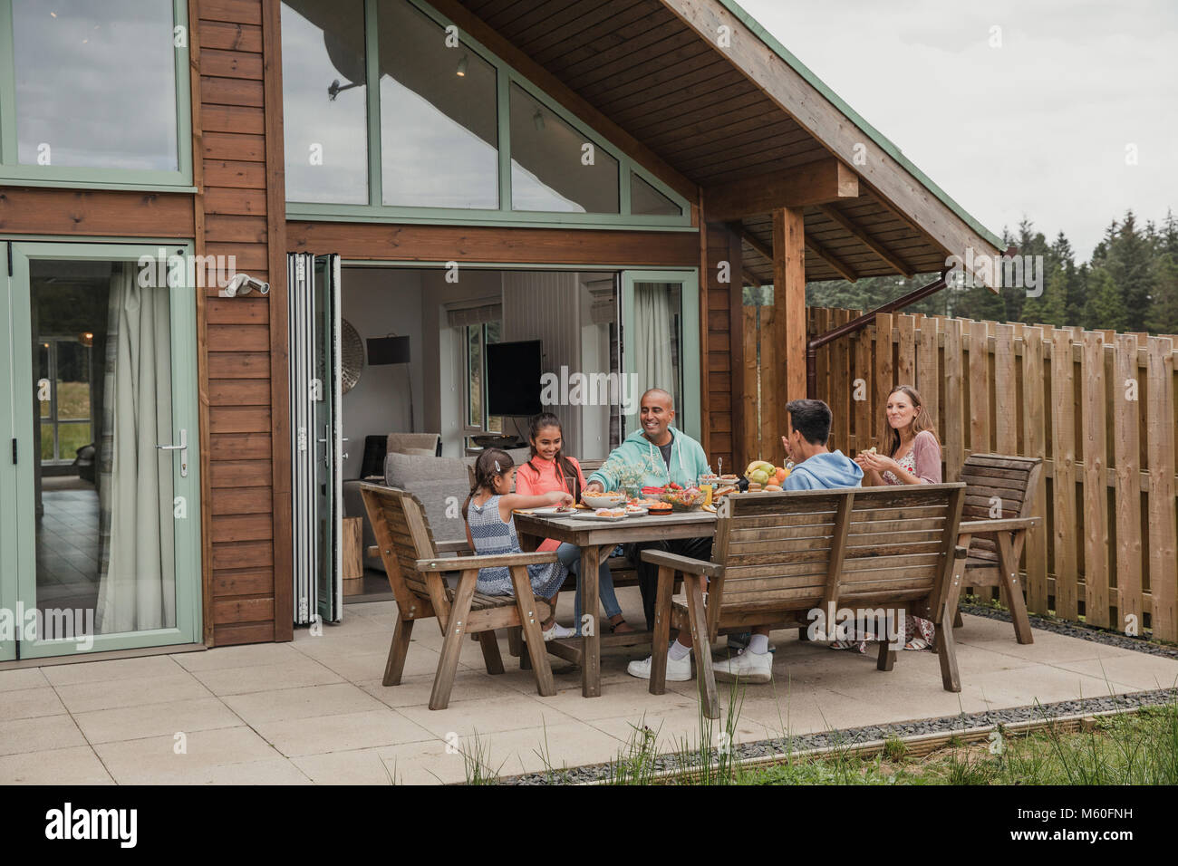 Family having their breakfast outside the holiday cottage Stock Photo ...