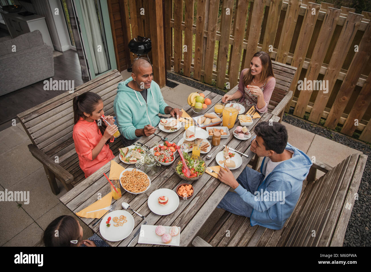 High angle view of family having breakfast outside of a holdiay cottage ...