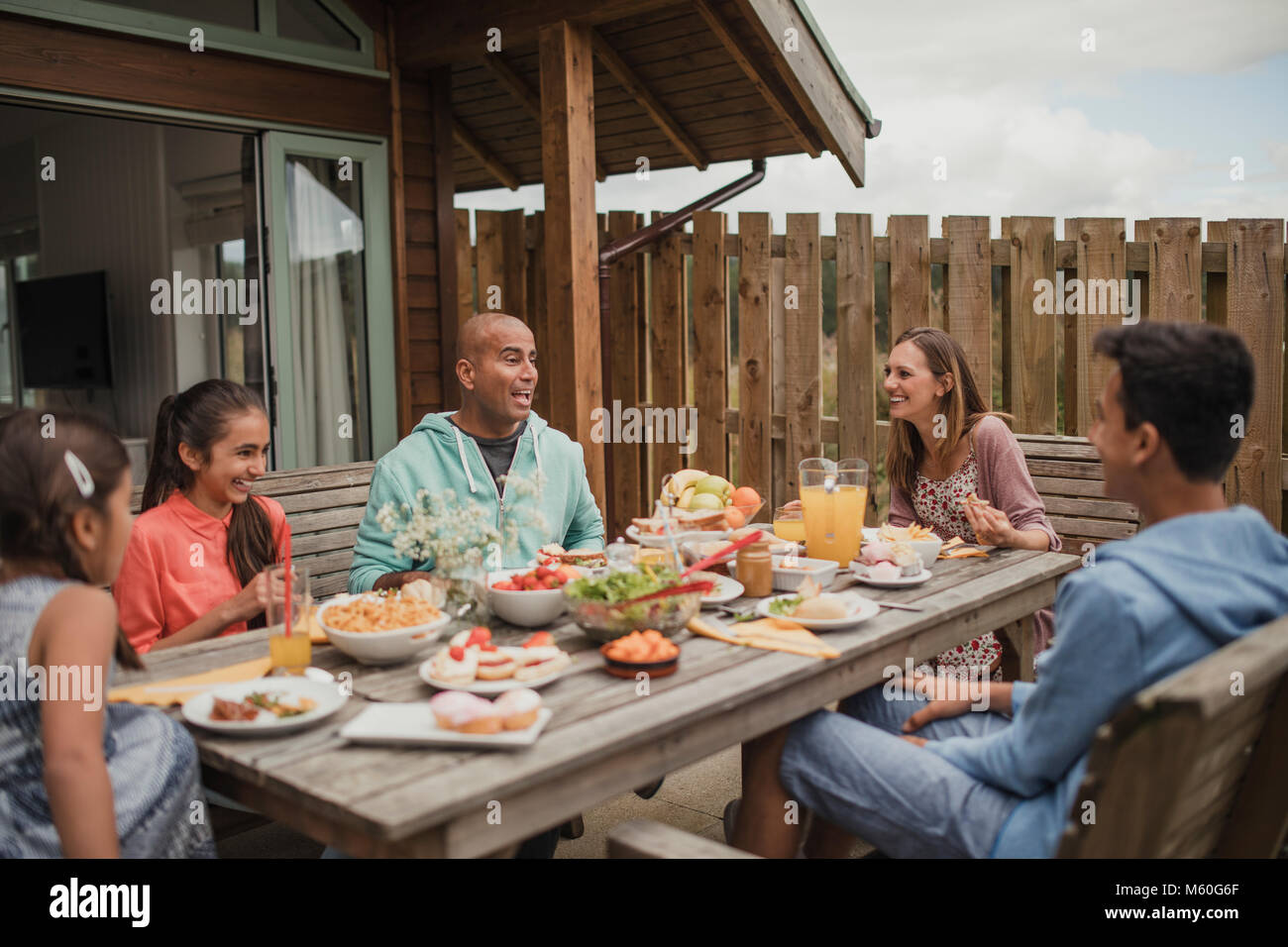 Family bonding and laughing, sitting having breakfast outside holiday ...