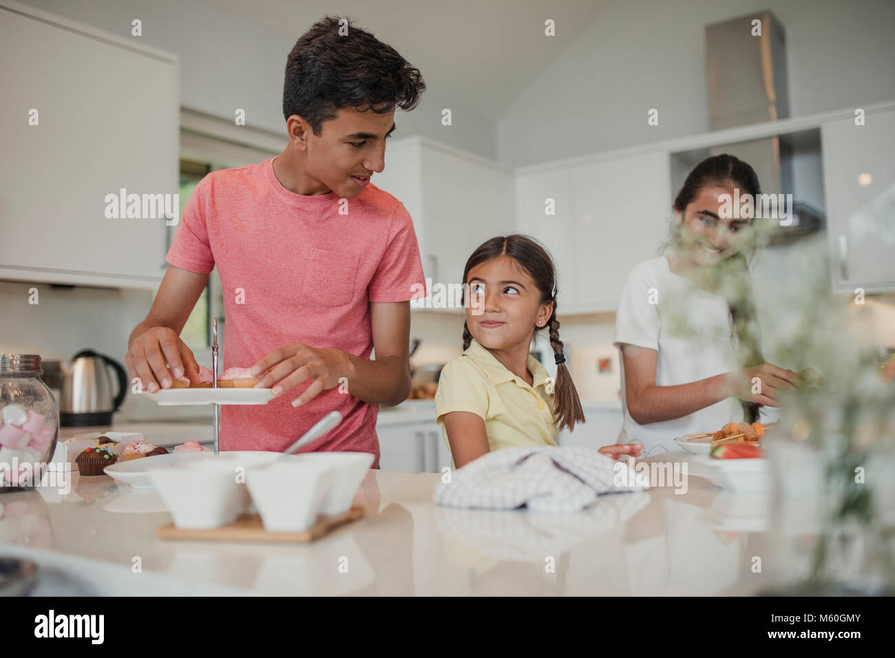 Siblings preparing food in the kitchen Stock Photo - Alamy