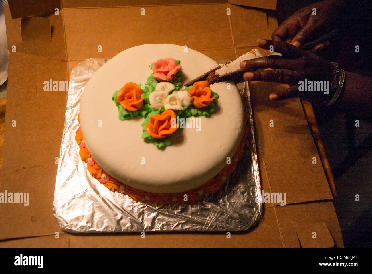 A cake celebrating a 75th birthday is cut in Craigston, Carriacou ...