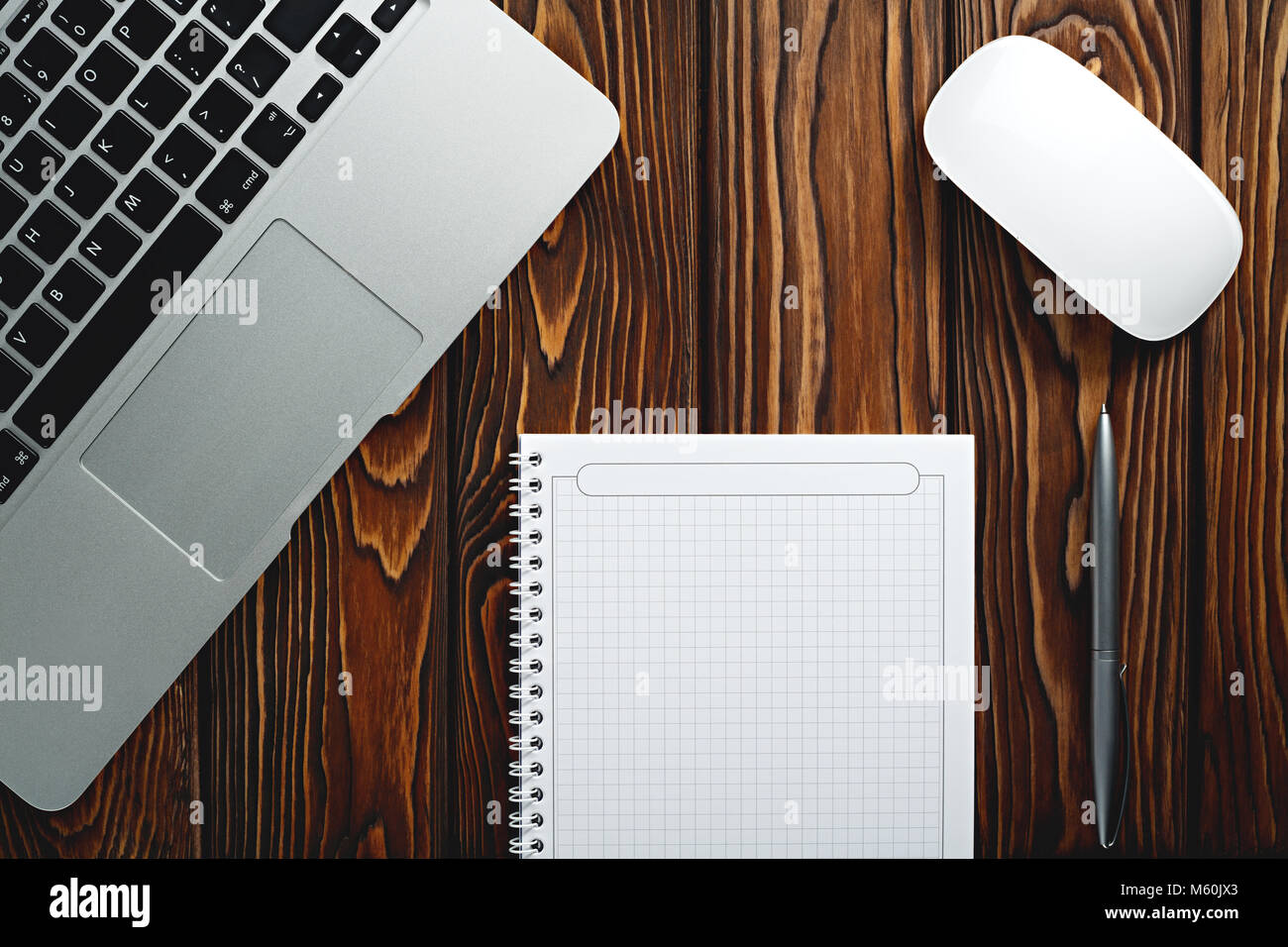 Notepad, laptop, and pen on wood texture table, start of Morning work ...