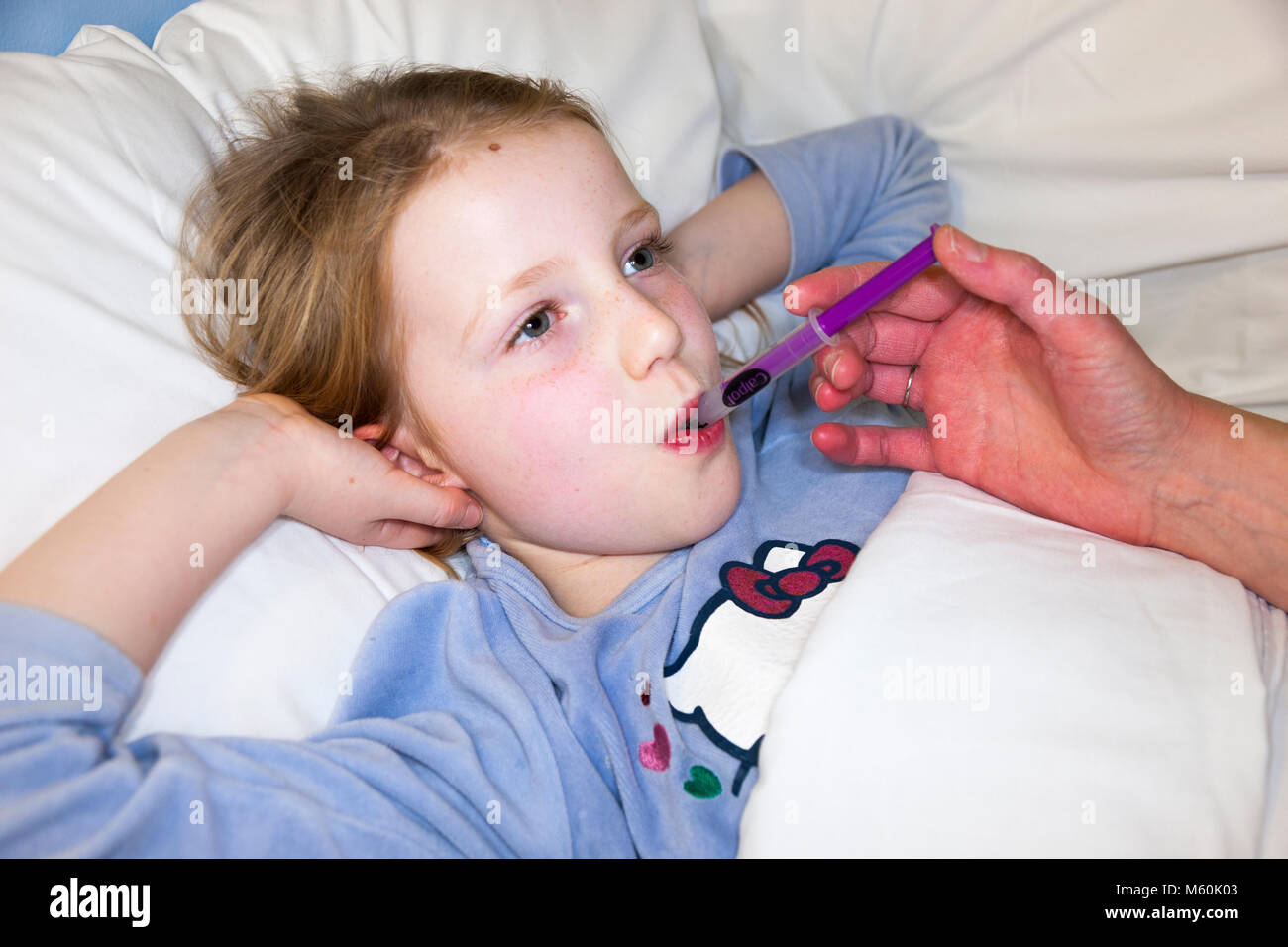 Mother / mum / mom giving Calpol medicine with paracetamol to – an ...