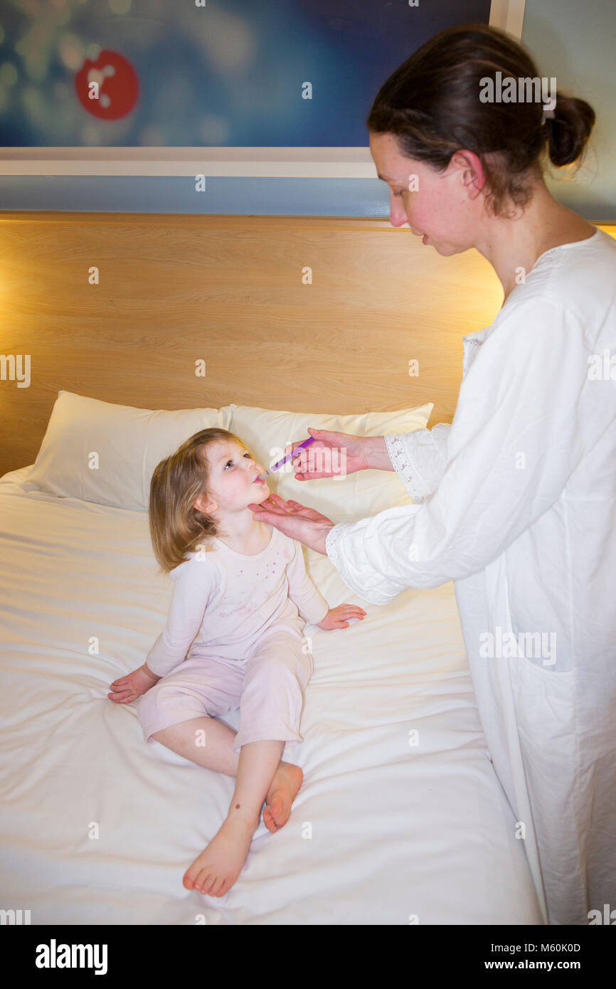 Holiday illness : mother / mum / mom giving Calpol medicine with ...